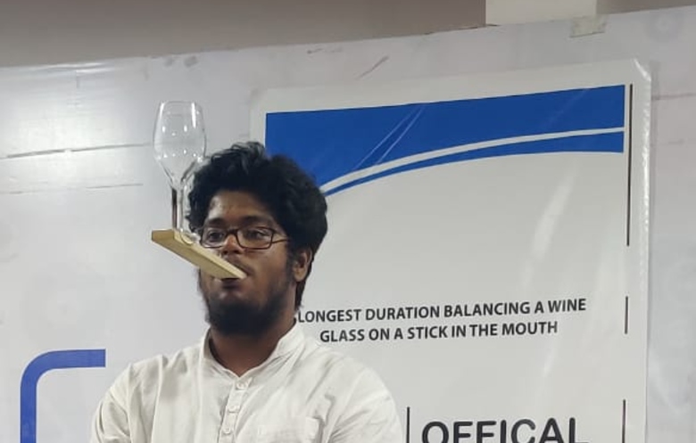 Longest duration balancing a wine glass on a stick in the mouth ...